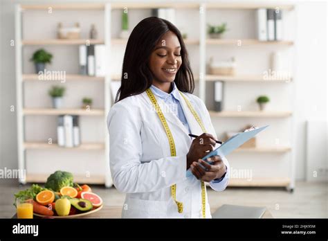 Cheerful Black Nutritionist With Clipboard Prescribing Healthy Diet Or