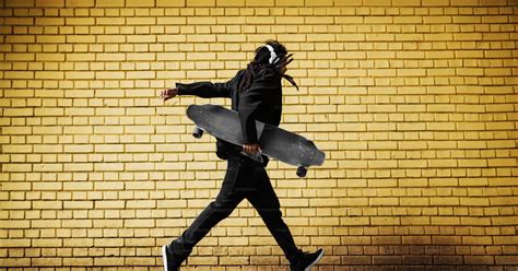 잘생긴 젊은 향취 스케이터가 거리의 노란 벽 근처에서 정장을 입고 헤드폰을 끼고 있습니다 사진 Unsplash의 브레이크 댄스 이미지