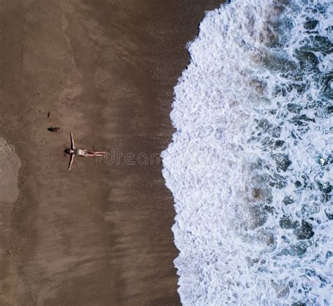 Aerial Top View Of Woman With Her Hands Outstretched Laying On The