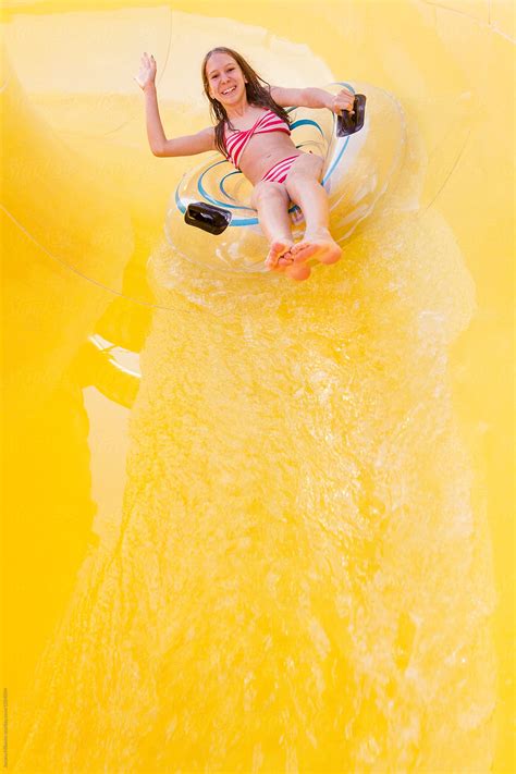 Young Girl Having A Lot Of Fun Sliding Down The Water Tube In Aqua