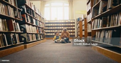 책 독서 지식 학습 및 유대감을 위해 도서관 바닥에 할머니와 함께하는 어린이 책장 문학 동화 및 교육 개발을위한 서점의 가족 및 소녀 도서관에 대한 스톡 사진 및 기타