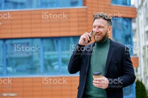 캐주얼 한 정장을 가진 매력적인 사업가가 전화로 이야기하고 배경에 도시 건물과 야외에서 서 커피 휴식을 취 30 34세에 대한 스톡 사진 및 기타 이미지 Istock