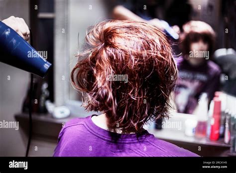 Hairdresser Blow Dries With Red Hair After A Haircut In A Teenage Girl