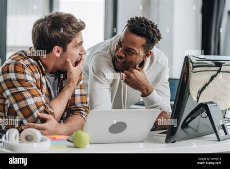 Two Shocked Multicultural Programmers Looking At Each Other While