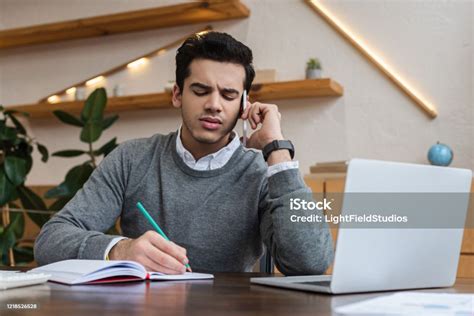 스마트 폰에 이야기하고 테이블에서 노트북 근처 노트북에 쓰기 사업가 갈색 머리에 대한 스톡 사진 및 기타 이미지 갈색 머리 남자 남자 사업가 Istock
