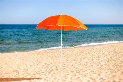 Premium Photo Orange Umbrella On The Beach