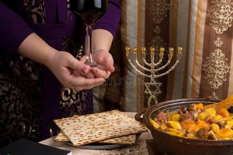 A Woman At A Table Laid For A Passover Seder Holds A Glass Of Red Wine