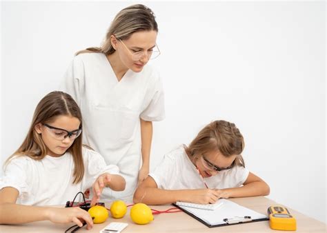 Meninas Fazendo Experimentos Científicos Com Limões E Eletricidade