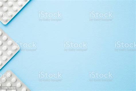 밝은 파란색 배경에 흰색 알약의 패키지 파스텔 색상입니다 의료 및 약국 개념 텍스트 또는 로고가 비어 있는 장소입니다 플랫 레이