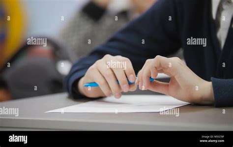 Classmates In Classroom During The Lesson Hands Holding Pen Stock