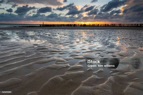 Zeeland의 Zoutelande의 해변에서 본 모래 사장과 네덜란드의 북해 위의 극적인 일몰 0명에 대한 스톡 사진 및 기타