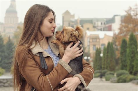 La Fille Tient Un Petit Chien Dans Des Ses Bras étreintes Et L