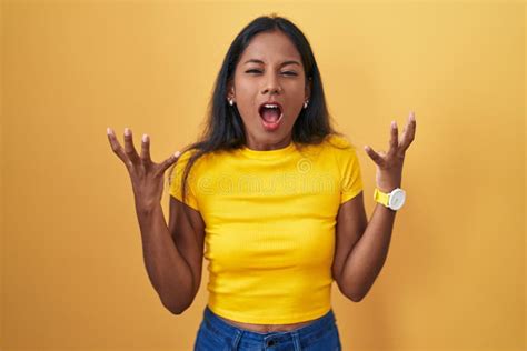Young Indian Woman Standing Over Yellow Background Crazy And Mad