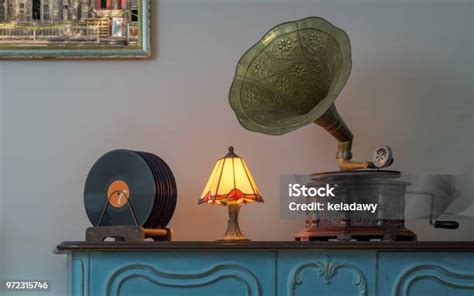 나무 테이블과 베이지색 벽과 교수형된 그림의 배경에서 19 세기 축음기 및 비닐 레코드 전경에 대한 스톡 사진 및 기타 이미지