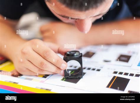 Young Man In The Process Of Printing Used Color Scales And Loupe And