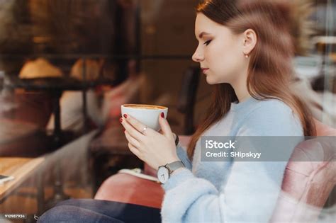 여자의 커피 컵을 보유 하 고 카메라를 봐 세련 된 의류를 착용 가과 겨울 날씨입니다 배경 흐림 Proffesional