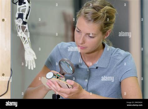 Woman Adjusts The Robot Arm Model Stock Photo Alamy