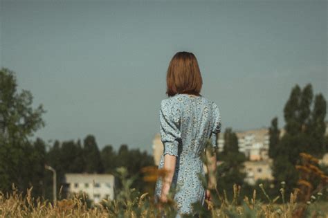 Foto Mujer Vestida De Blanco Y Negro Parada En Un Campo De Hierba Verde