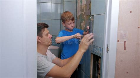 Dad And Son Make Repairs Together At Home Remove Tiles From Walls In