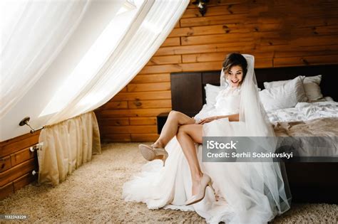 그녀의 세련 된 클래식 래커 베이 지 신발을 착용 신부 우아한 여성은 자연 햇빛에 배경 흰색 드레스에 결혼식 신발에 손을