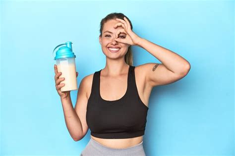 Premium Photo Sporty Blonde With A Protein Shake In A Studio Excited