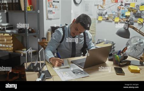 Hispanic Detective Taking Notes At Police Station With Evidence Board