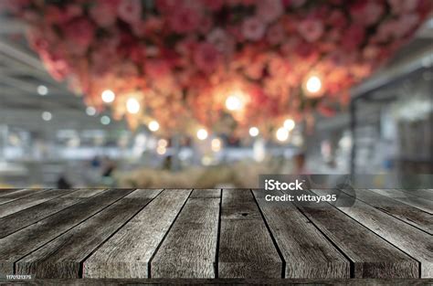 커피 숍 카페에서 보케 빛추상 핑크 컬러 꽃의 흐릿한 이미지와 빈 회색 나무 테이블 이나 테라스 제품 또는 개체 프리젠 테이션 및 정원 개념의 디스플레이를위한 복사 공간 0