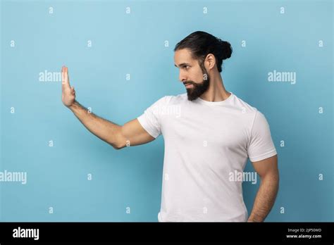 Side View Of Man With Beard Wearing White T Shirt Showing Stop Gesture