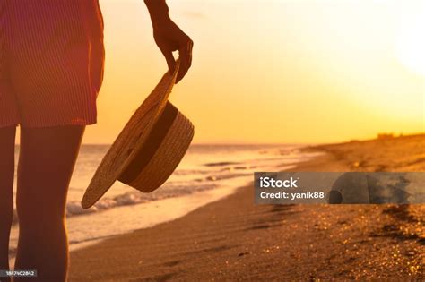 여성이 들고 있는 밀짚모자의 세부 묘사 바다 또는 바다를 배경으로 여성의 손에 밀짚 모자를 클로즈업합니다 휴가 컨셉입니다 바다