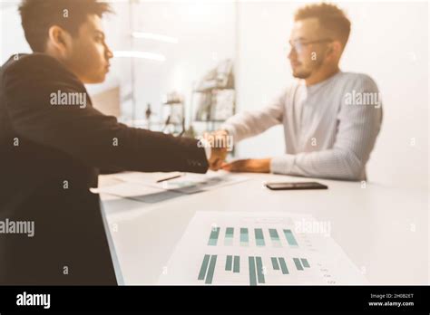 Jeune employé de bureau assis au bureau à l aide d un ordinateur Deux