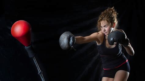 아름 다운 여성 펀칭 A 복싱 체육관에서 권투 장갑 가방 스포츠 피트 니스에 대 한 개념입니다 킥복싱과 싸움 스포츠 개념입니다