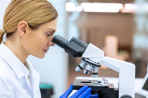 Scientist Looking Biochemical Cell In Laboratory Using Microscope