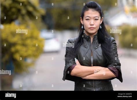 Portrait Of Beautiful Asian Rebellious Woman With Arms Crossed Outdoors