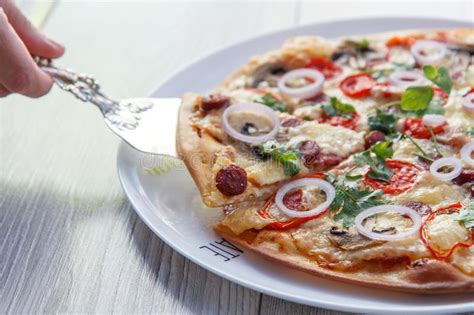 Sliced Whole Fresh Pizza With Tomatoes Salami Cheese And Mushrooms On