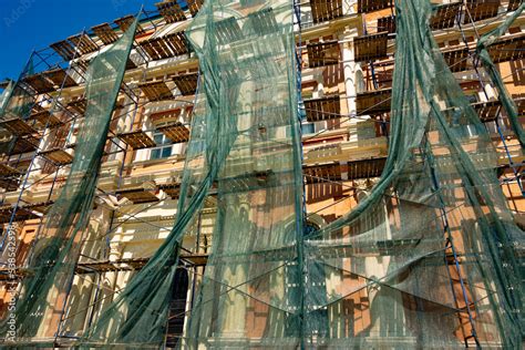 building structure with netting shade and scaffolding covered stock