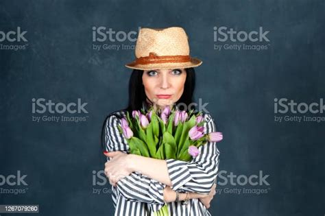 트렌디 한 아름다운 소녀 여름 밀짚 모자와 줄무늬 셔츠에 갈색 머리 튤립 꽃의 꽃다발 카메라 여름의 테마 봄을 본다 갈색 머리에 대한 스톡 사진 및 기타 이미지 Istock