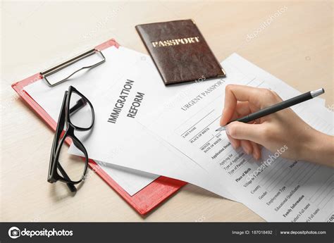 Woman Filling Urgent Passport Application Form At Table Immigration And Citizenship — Stock