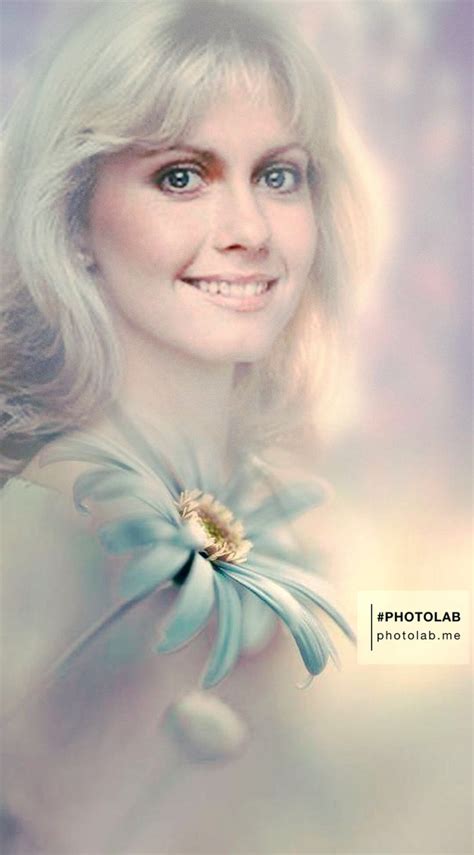 A Woman With Blonde Hair And Blue Eyes Holding A Flower