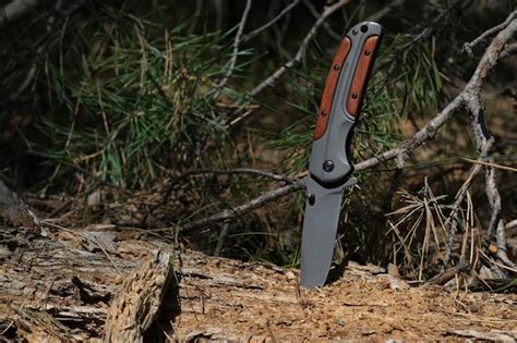 Couteau de survie pliant avec inserts en bois dans le manche est coincé