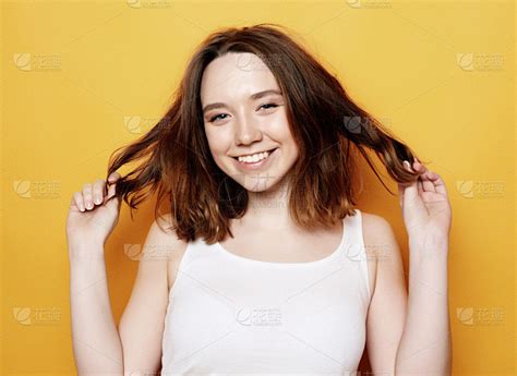 美丽快乐的女孩抚摸着她的头发