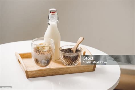 건강 한 식사를 영양가 있는 아침 식사아몬드 Chia의 종자 바나나 키 위 과일과 열매와 그 라 놀라와 인근 우유 병 땅콩버터에