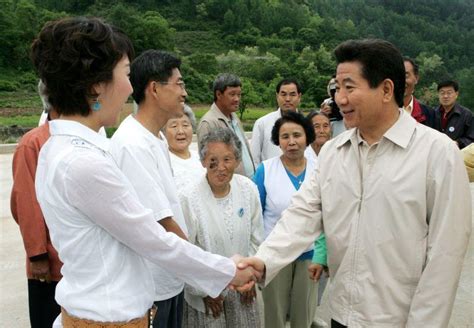 [노무현사료관] [농산촌 관광마을 방문 중 최은경 아나운서와 악수하는 노무현 대통령]