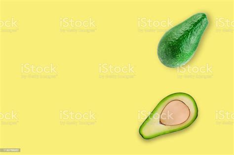 신선한 전체와 부엌 또는 시장에서 노란색 테이블에 커널을 가진 유기농 아보카도의 절반 평면도 요리 개념입니다 텍스트의 공간 복사