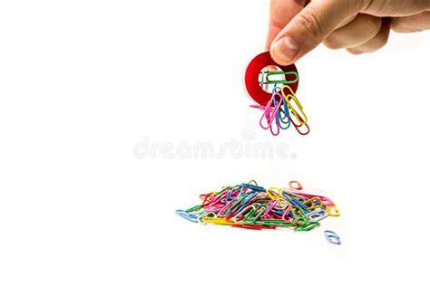 Sirva La Mano Que Sostiene El Imán Que Atrae Los Clips De Papel Del