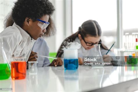 10대 귀여운 어린 학생들이 학교 실험 실험실 수업에서 시험관에 액체를 만들고 분석하고 혼합하면서 연구를 배우고 화학 실험을 하는 그룹입니다 교육 아이에 대한 스톡 사진 및