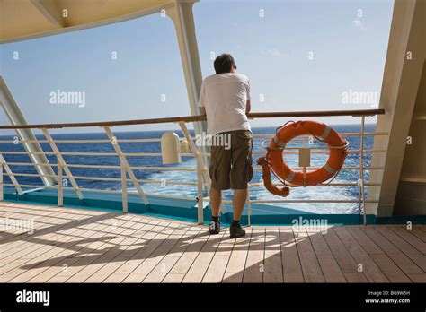 Man Leaning On Railing On Cruise Ship Deck Stock Photo Alamy