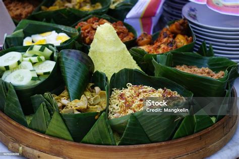 추수 감사를위한 인도네시아의 다양한 음식 인도네시아 사람들은 그것을 나시 툼펭이라고 부릅니다 툼펭은 원뿔 모양의 노란 쌀 프라이드 치킨 자바 샐러드 및 기타 음식을