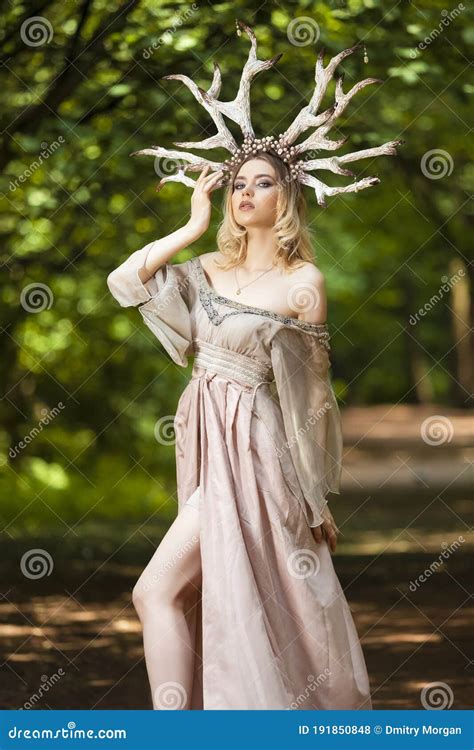 Young Beautiful Girl Posing With Artistic Deer Horns In Summer Forest