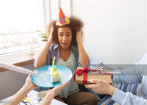 파란 셔츠에 있는 소녀는 오늘 생일이 있습니다 그녀의 친구는 그녀를 위해 약간의 놀라움을 만들었습니다 그들은 현재와 촛불을 가진