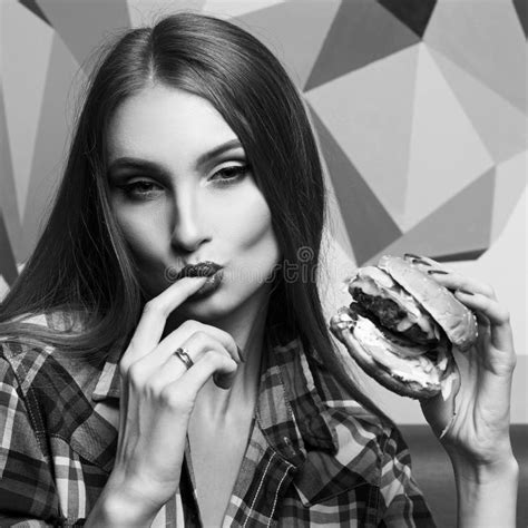 Beautiful Woman Holding Burger And Licking Her Finger Stock Image